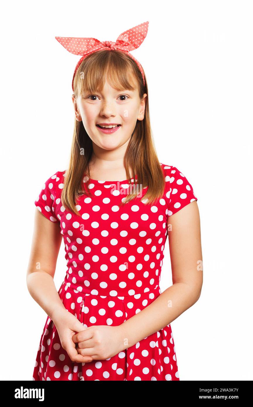 Studio shot of young little 9-10 year old girl, wearing red polka dot ...