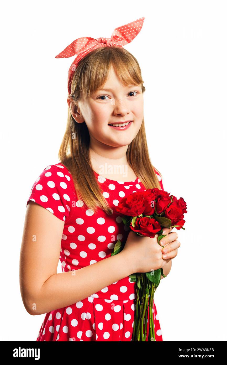 Studio shot of young little 9-10 year old girl, wearing red polka dot ...