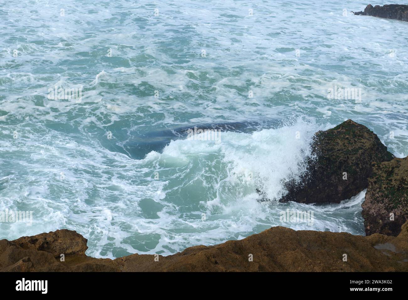 View from of above waves breaking on headland and making splashes and whirlpool. Copy ...