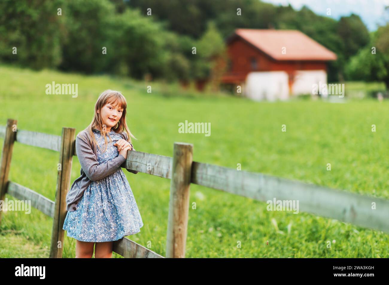 Pretty kid girl playing in a beautiful summer park at sunset, resting ...
