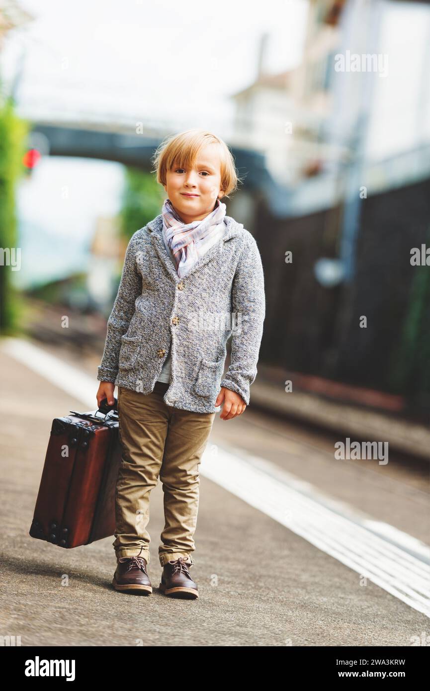 Adorable little boy on a railway station, waiting for the train with ...
