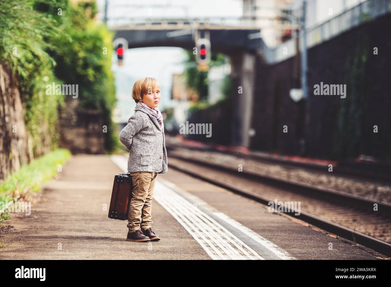 Adorable little boy on a railway station, waiting for the train with suitcase Stock Photo - Alamy