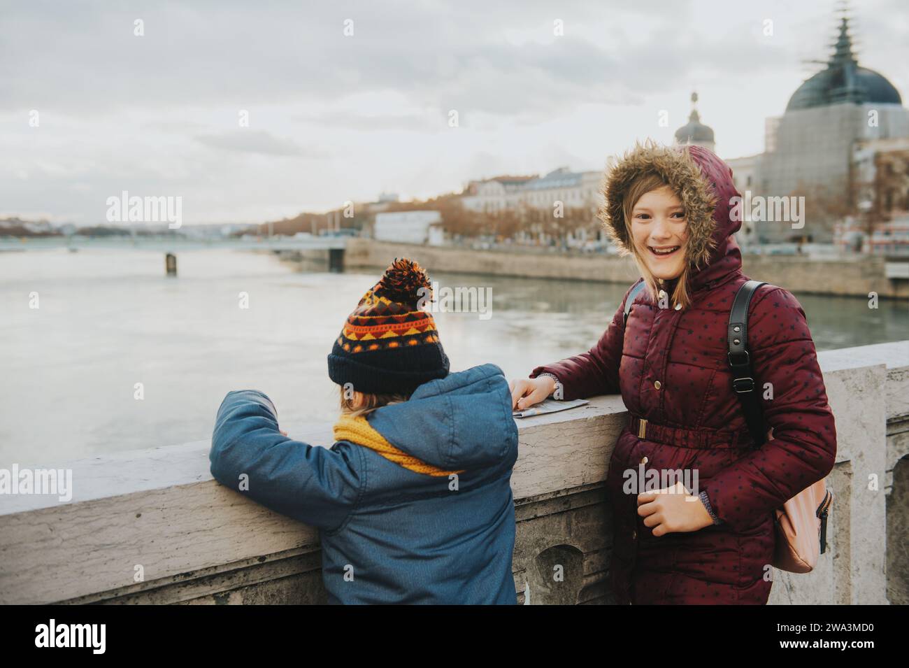 Little kids tourists admiring Rhone river from Bonaparte Bridge, Lyon ...
