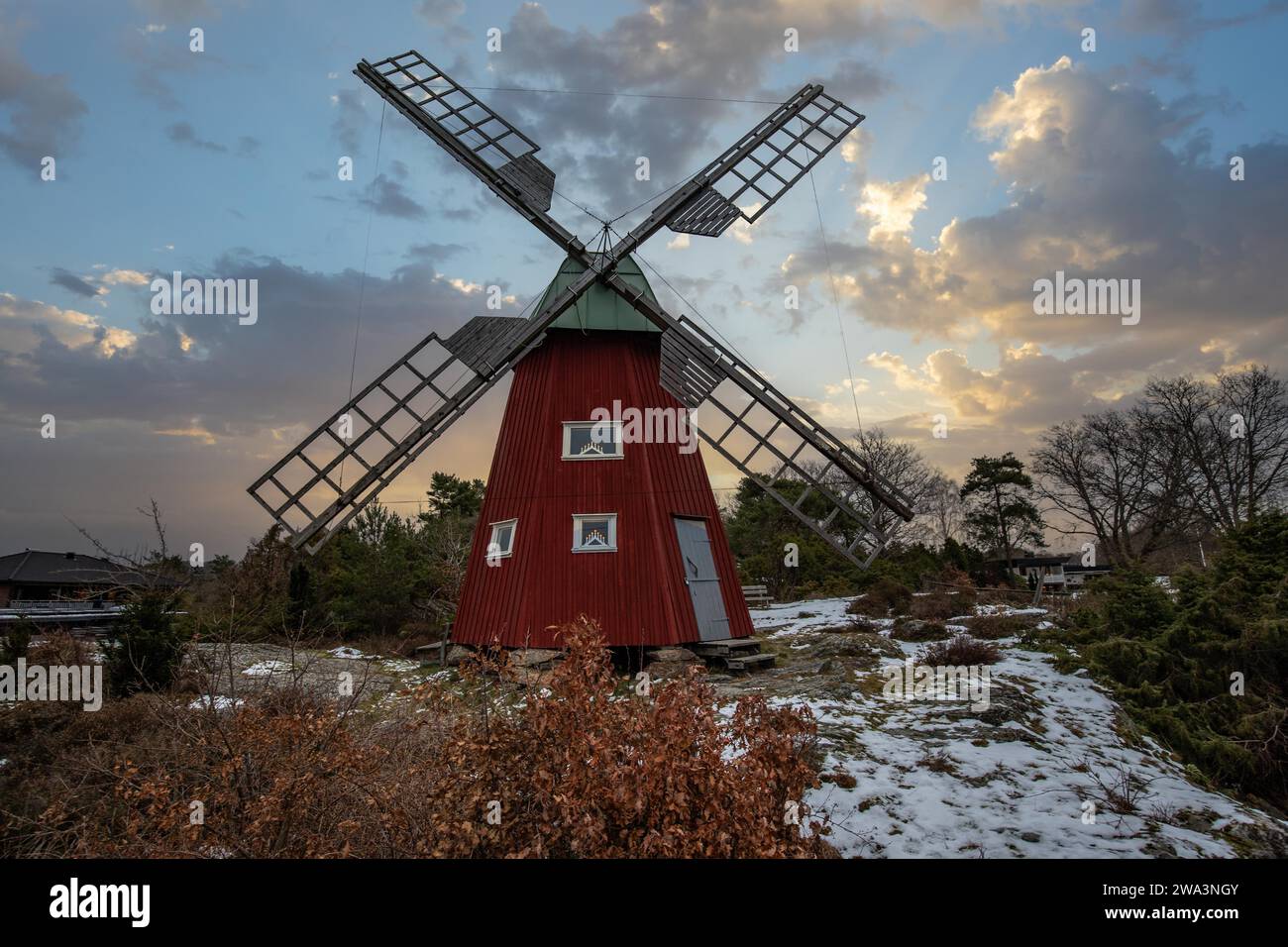 Typical historic windmill made of red wood in a winter landscape. The ...