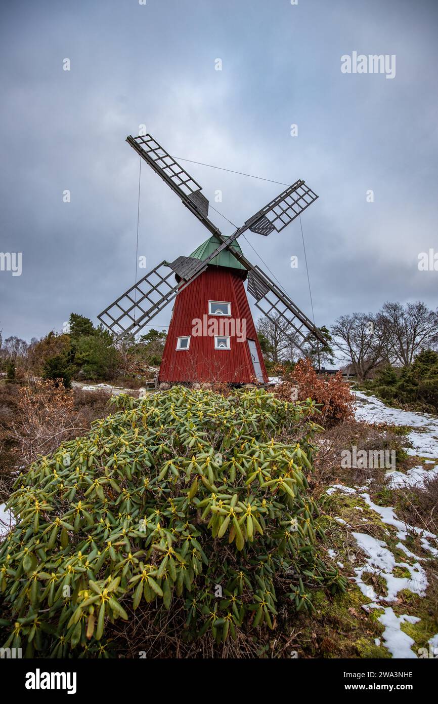 Typical historic windmill made of red wood in a winter landscape. The ...