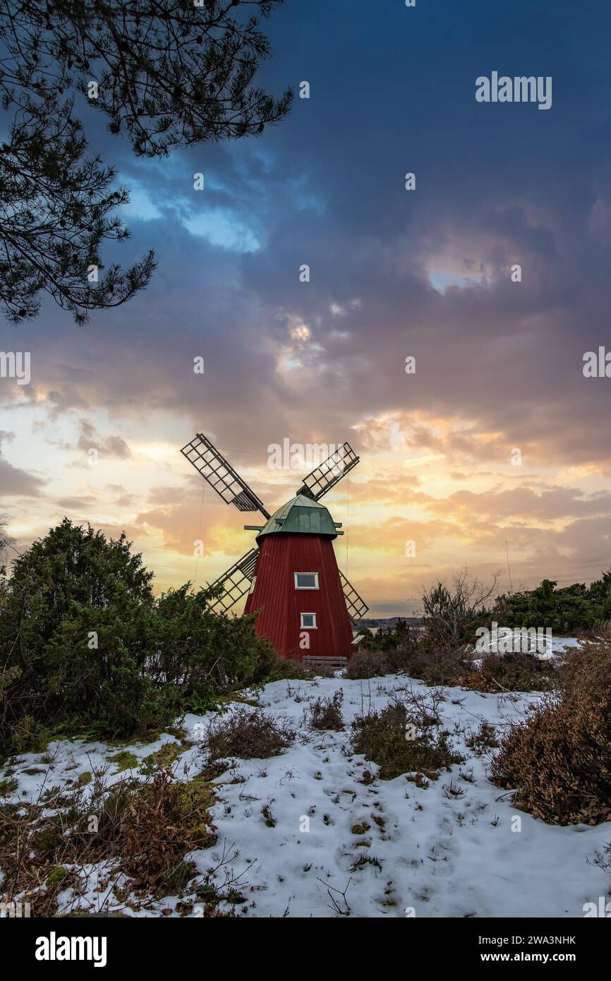 Typical historic windmill made of red wood in a winter landscape. The ...