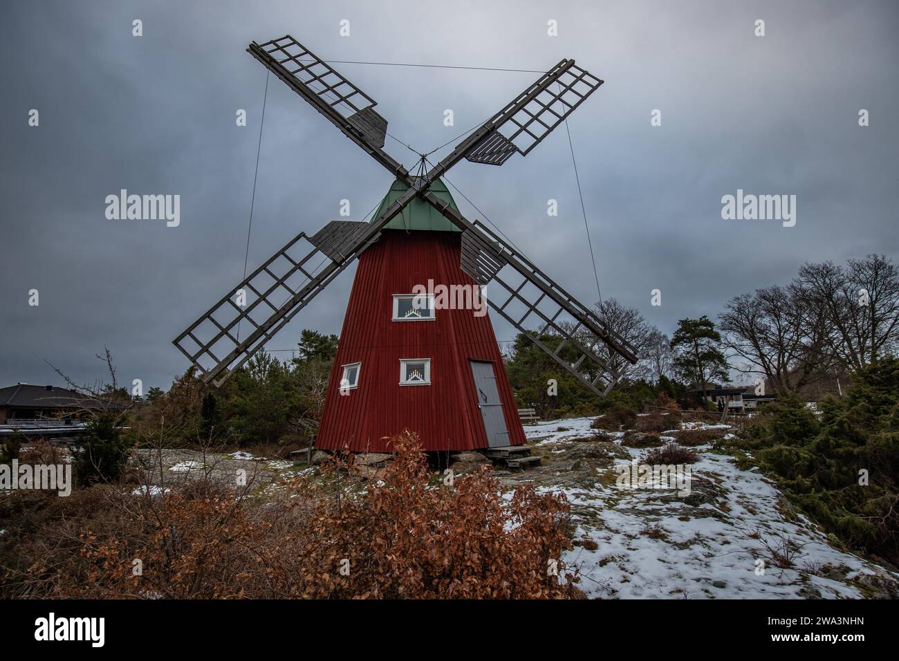 Typical historic windmill made of red wood in a winter landscape. The ...