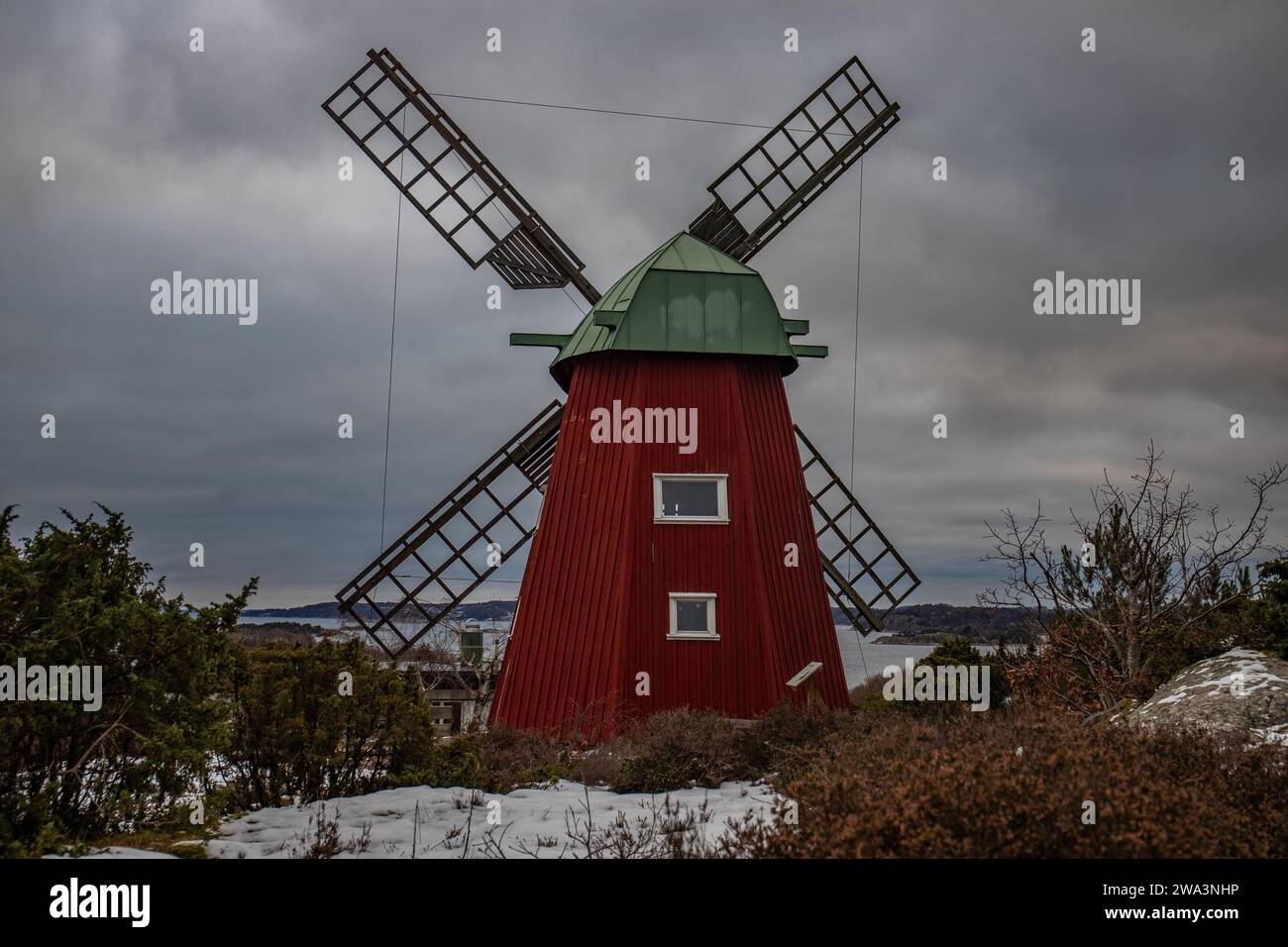 Typical historic windmill made of red wood in a winter landscape. The ...