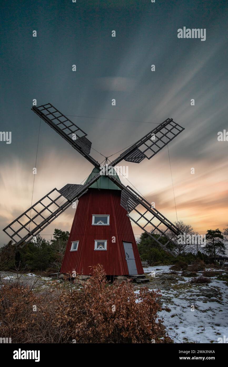 Typical historic windmill made of red wood in a winter landscape. The ...