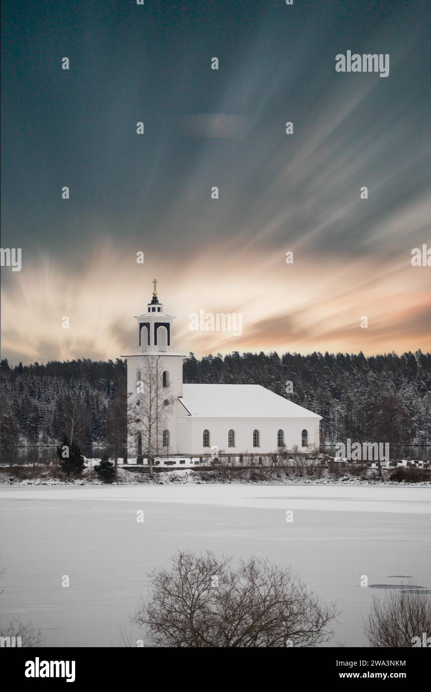 Small white church on a frozen lake in a cold winter landscape with ...