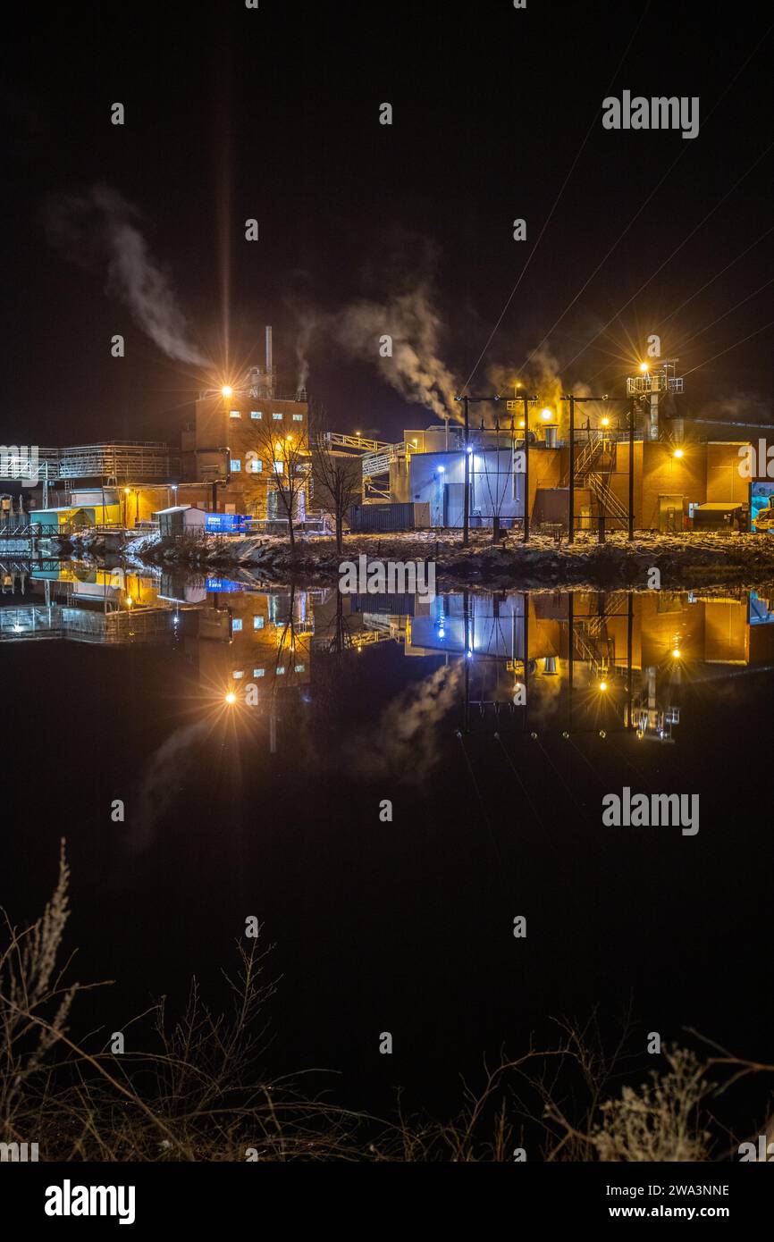 Paper factory at night. Winter photo of a small factory with reflection ...