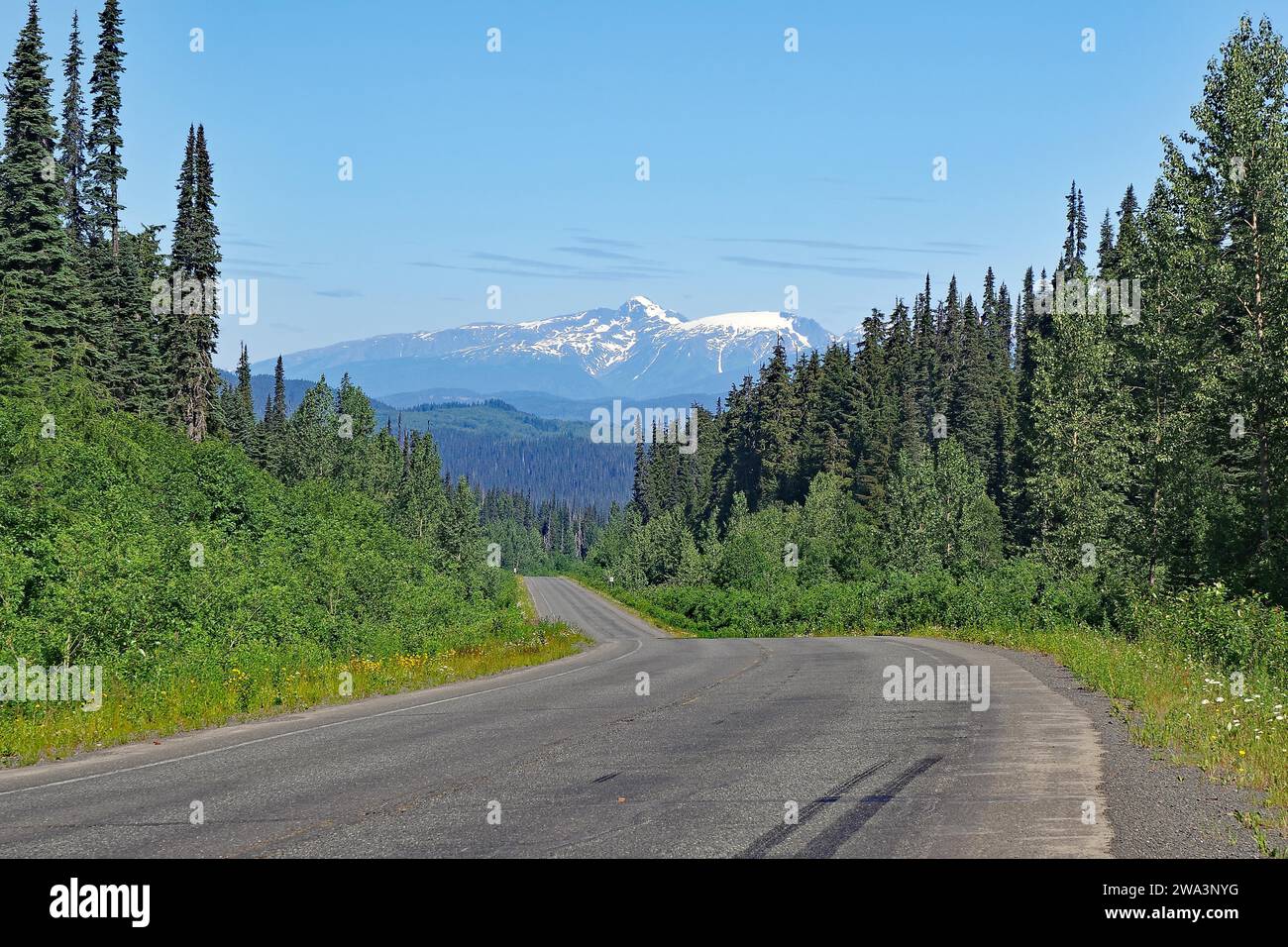 Narrow, traffic-free road leads through rugged mountain landscape ...