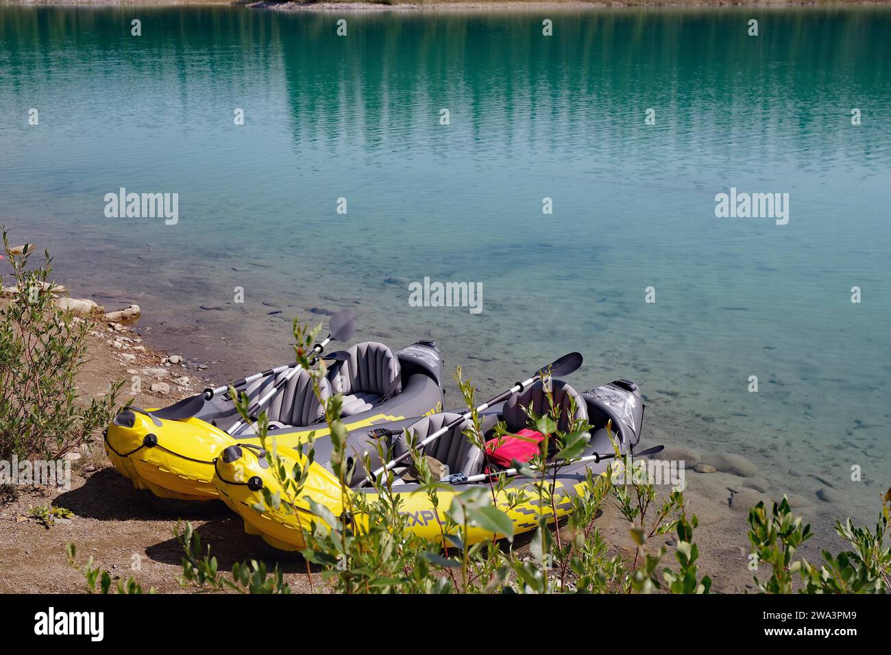 Boats moored on the shimmering green waters of Boya Lake, Wilderness ...