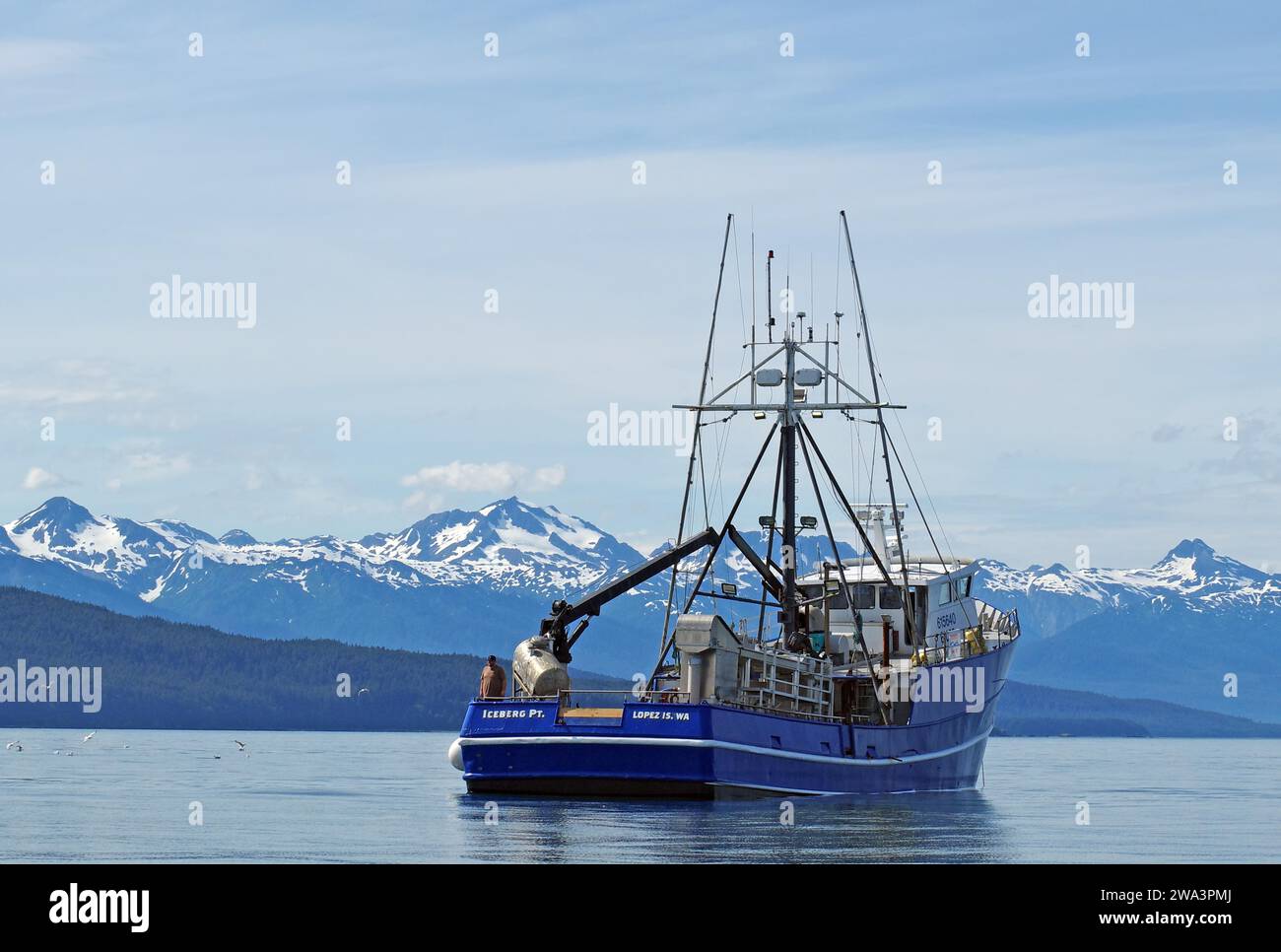 Fishing boat in front of high snow-covered mountains, Juneau, Inside ...
