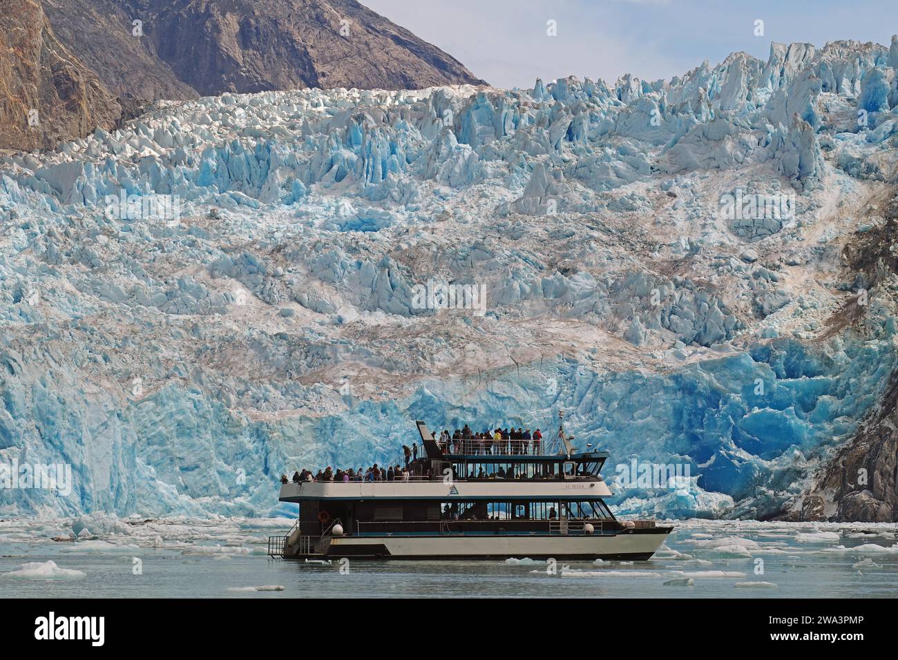 Small boat in front of a glacier calving into the sea, Tracy Arm Fiord ...