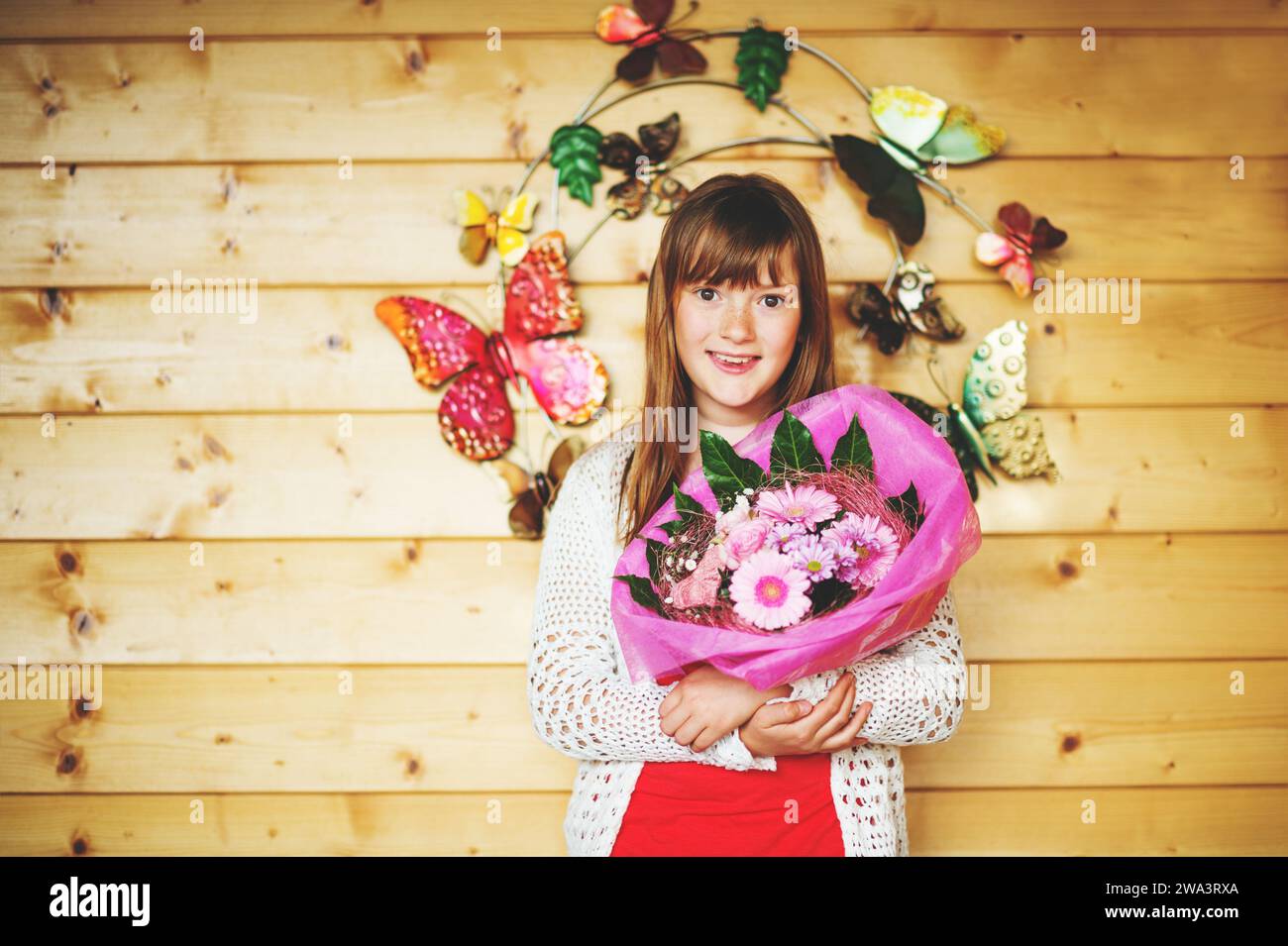Close up portrait of adorable brown hair kid girl holding big flower ...