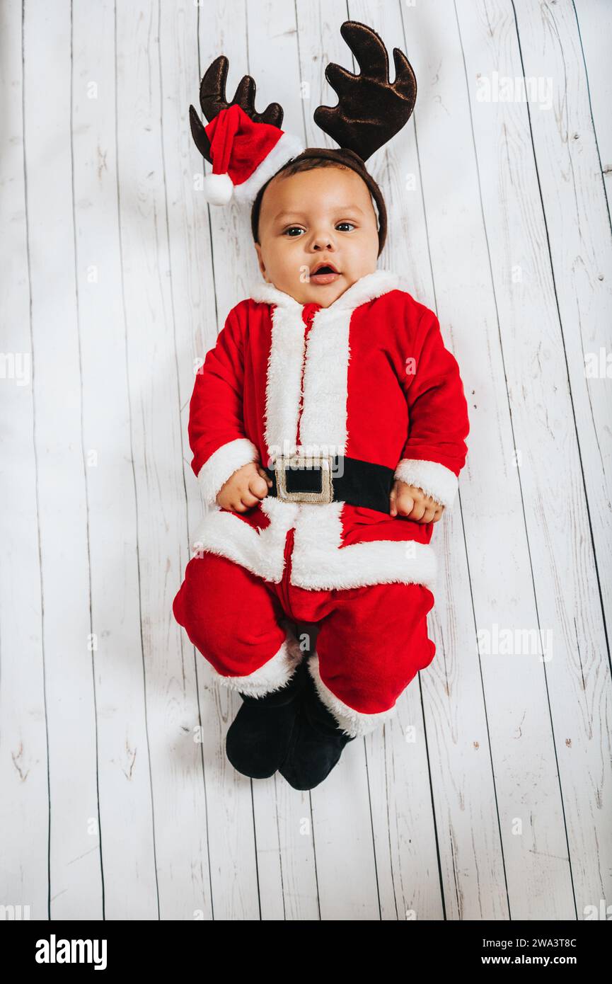 Christmas portrait of adorable baby boy lying on white background ...