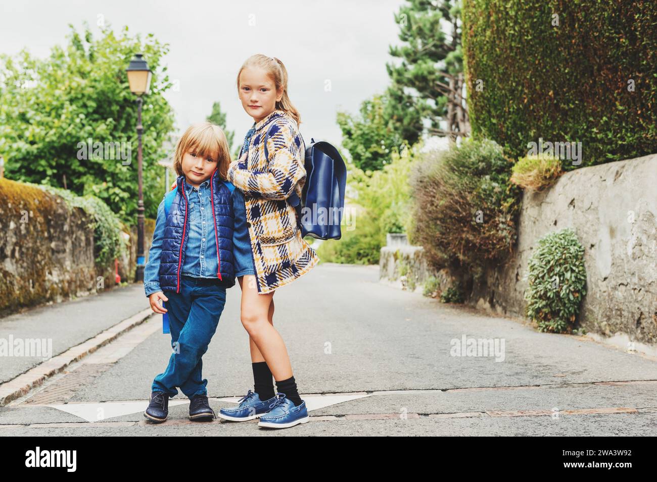 Cute kids with backpacks walking to school Stock Photo - Alamy