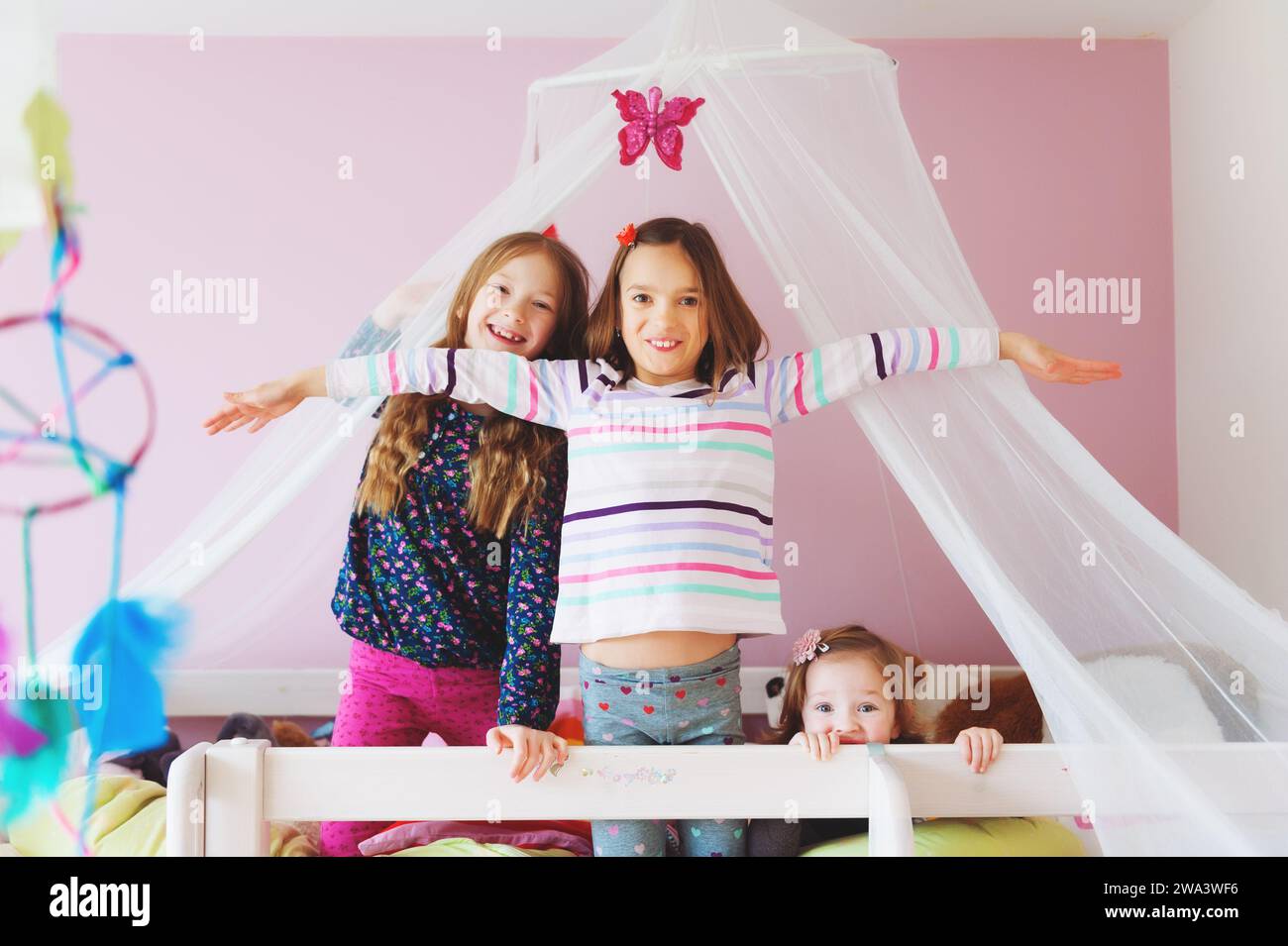 Three little girls playing in kid's room Stock Photo - Alamy