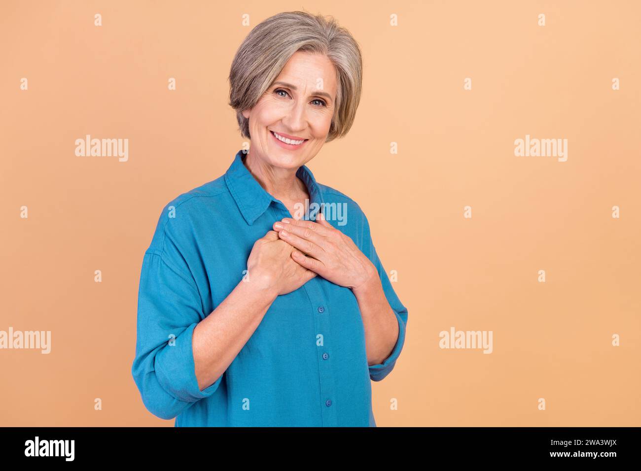 Photo of thankful positive senior woman with bob hairstyle dressed blue ...