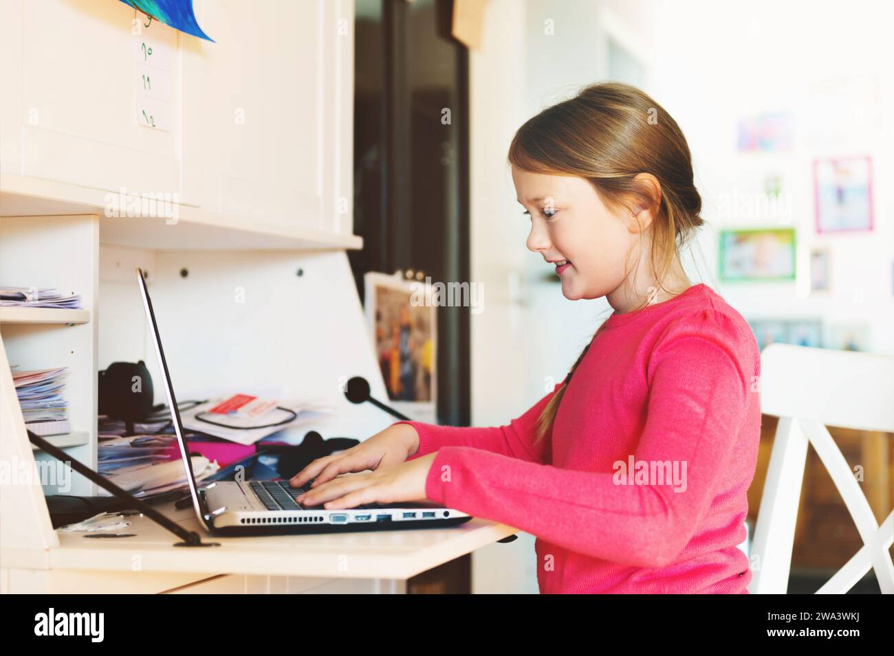 Little girl doing school homework with laptop pc Stock Photo - Alamy
