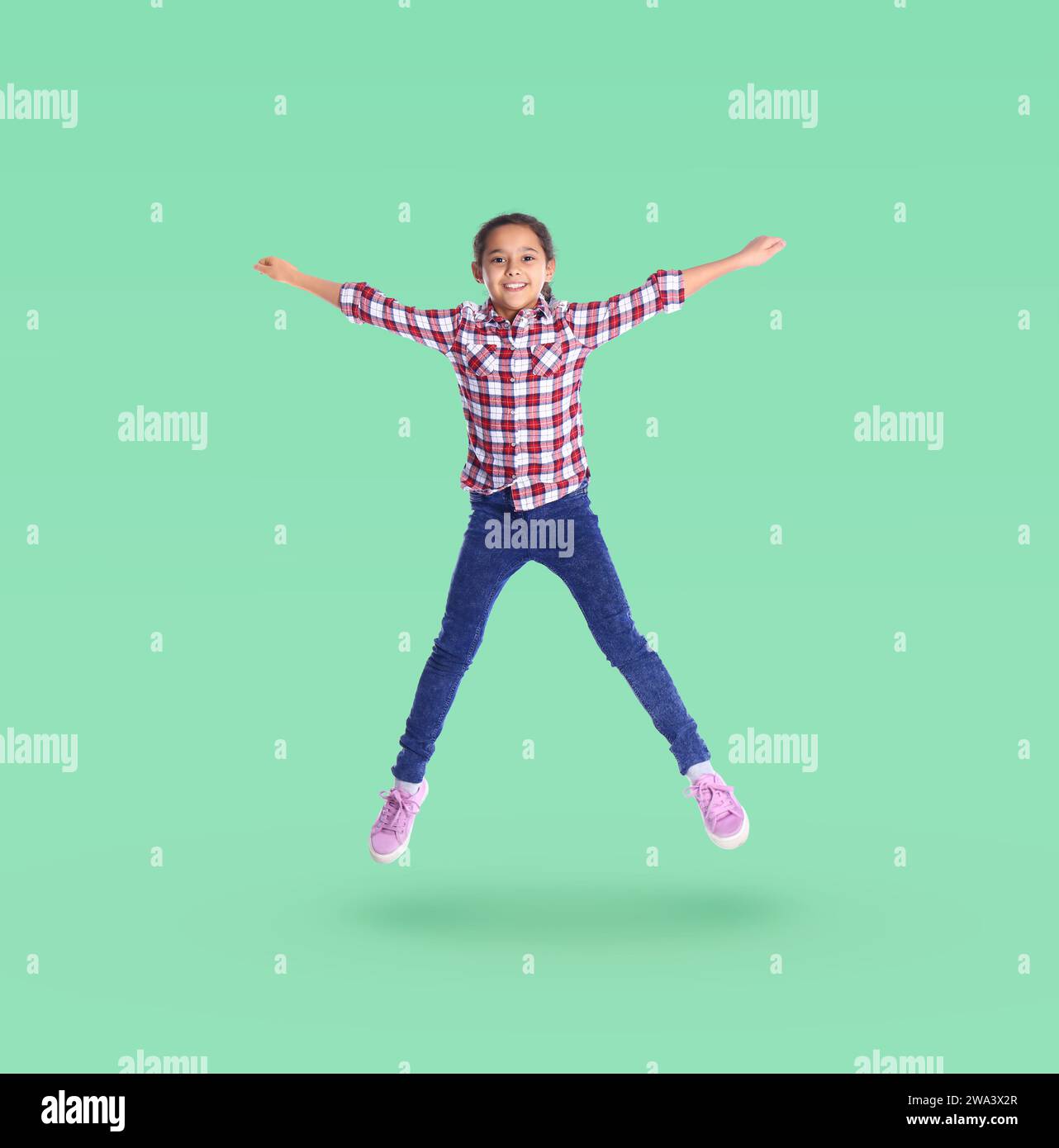 Happy cute girl jumping on aquamarine background Stock Photo - Alamy