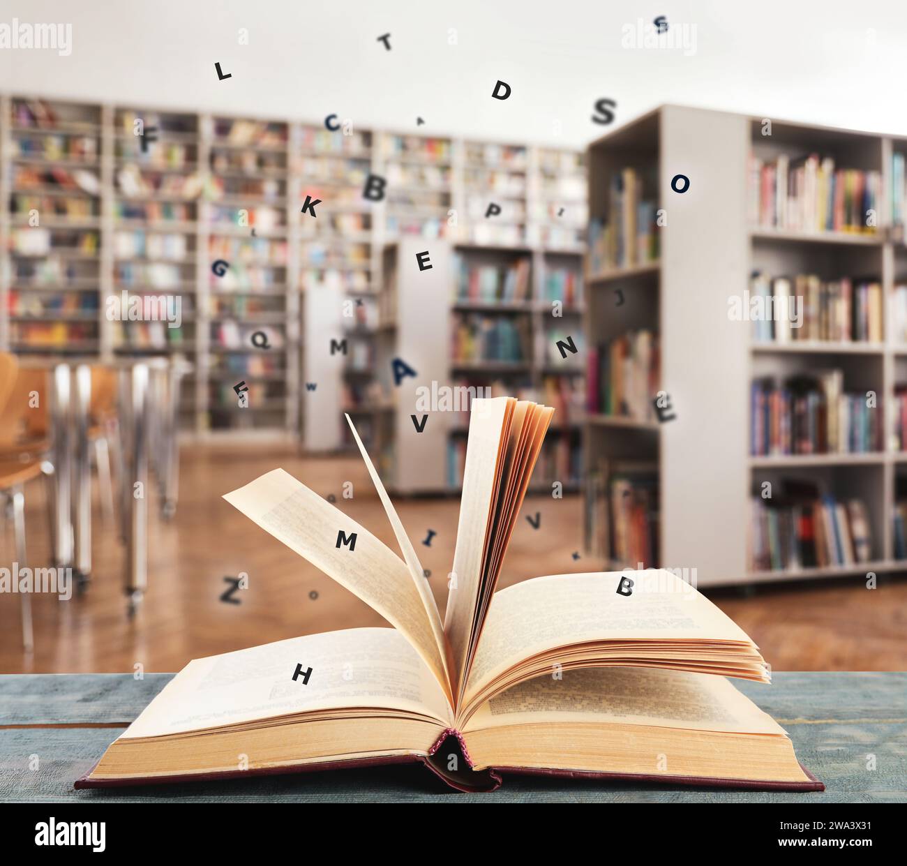 Open book with letters flying out of it in library Stock Photo - Alamy