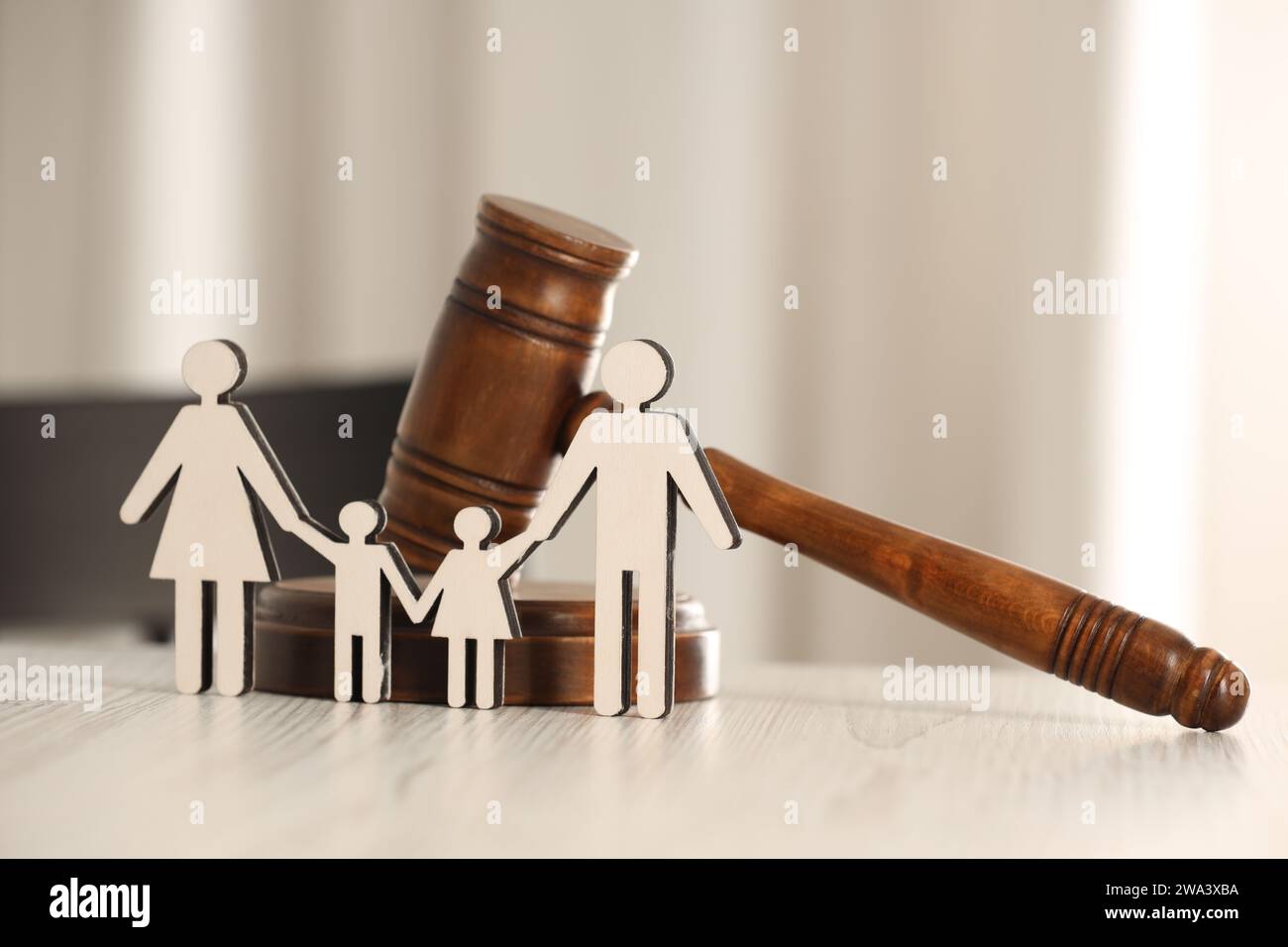 Law concept. Gavel and figures of parents with children on white wooden ...
