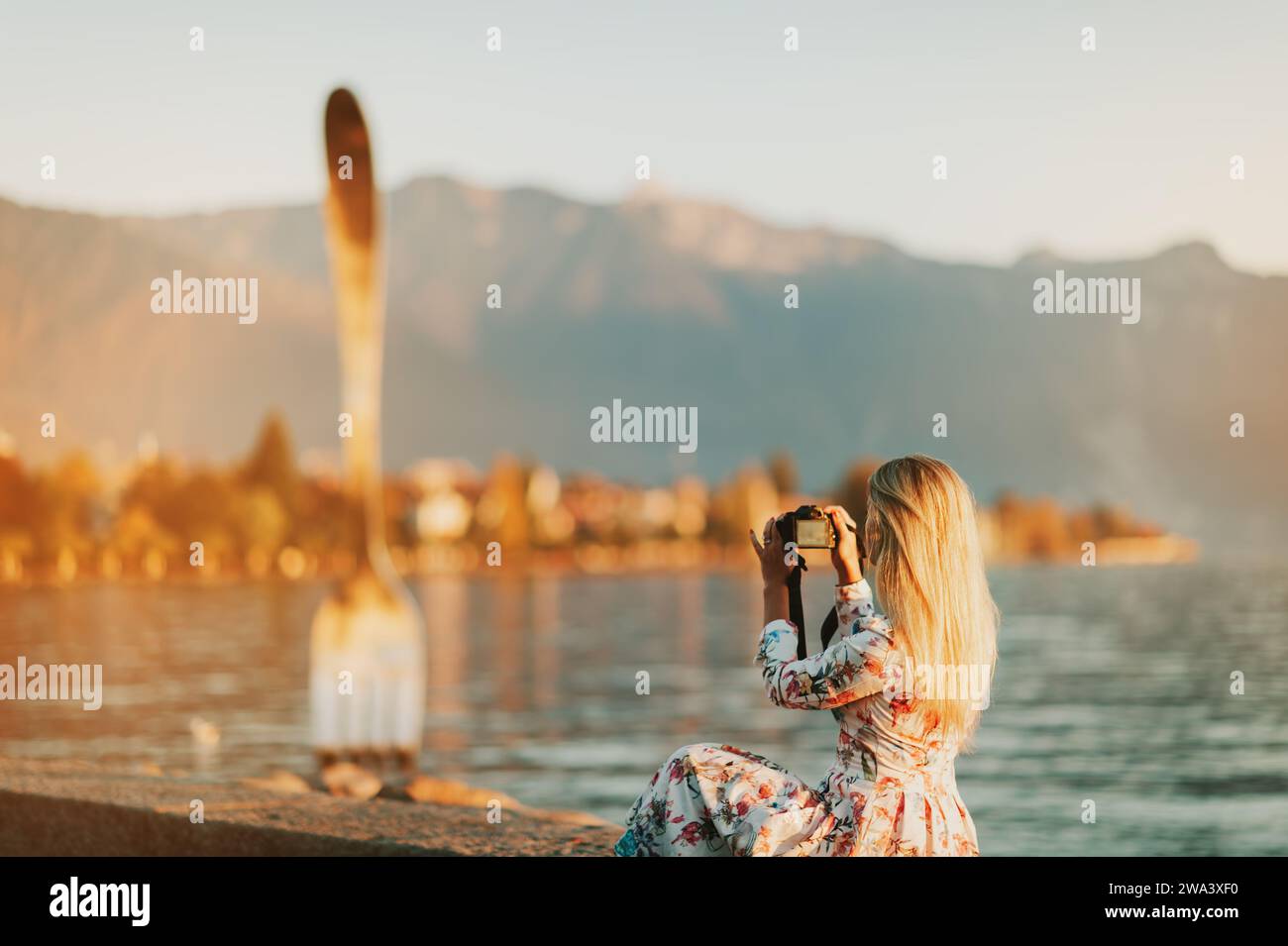 Girl tourist taking picture of famous fork on lake Geneva, Vevey ...