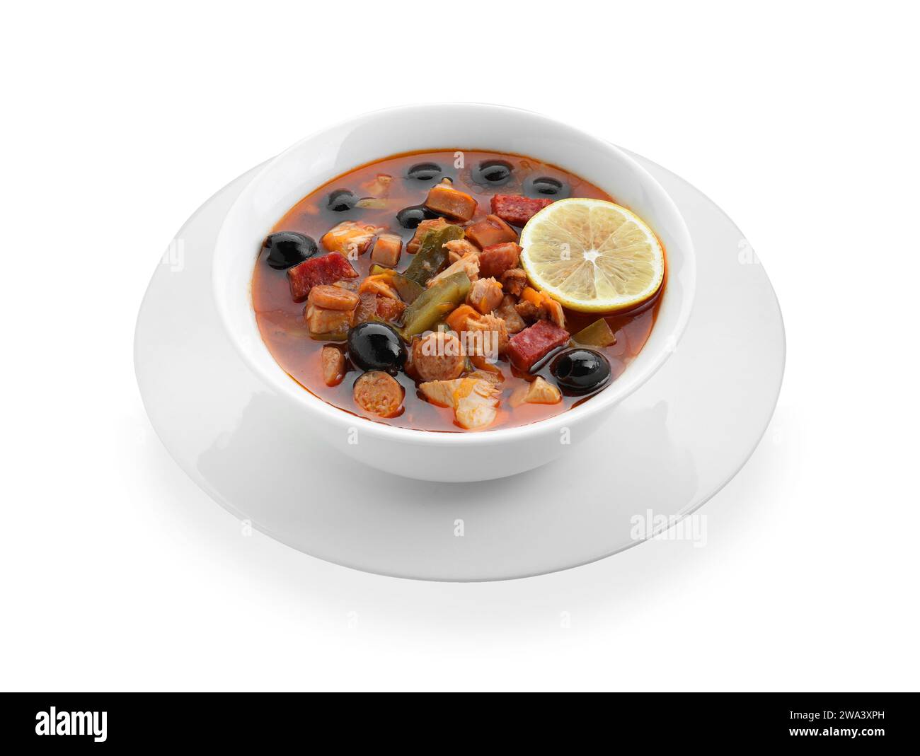 Meat solyanka soup with sausages, olives and vegetables in bowl ...