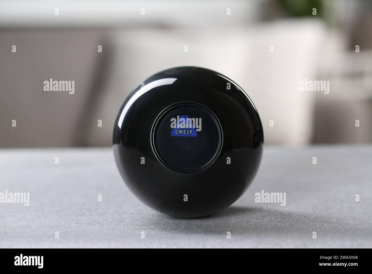Magic eight ball with prediction Very Likely on light gray table ...