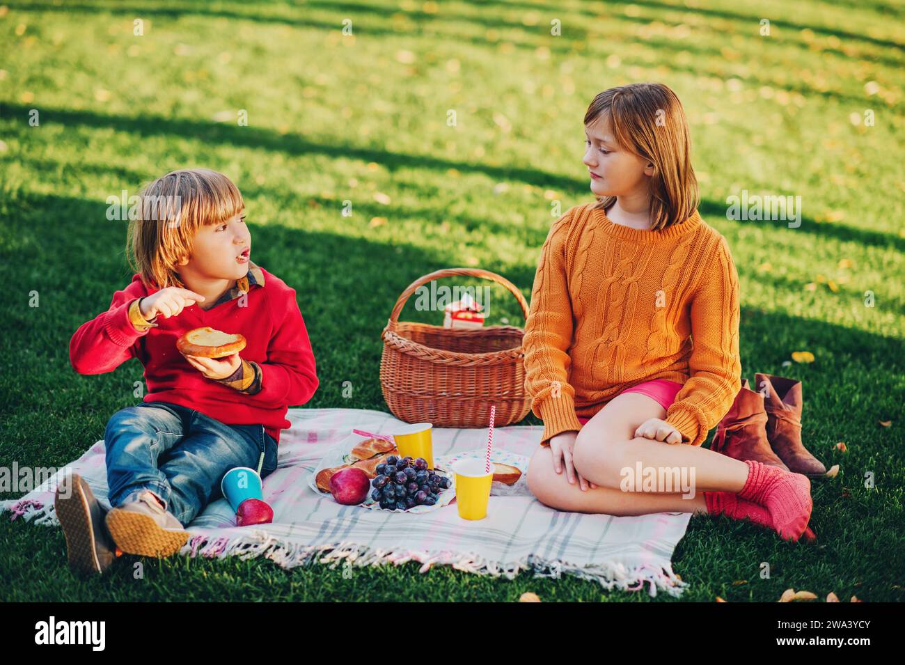 Kids eating snacks outside. Children resting in the park on a nice ...