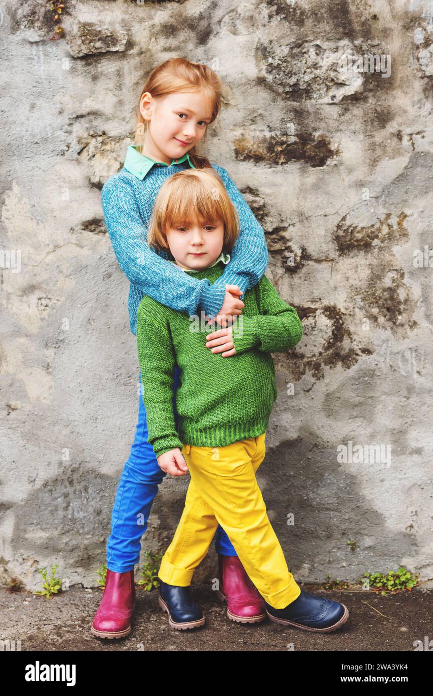 Outdoor portrait of two little kids, brother and sister, wearing ...