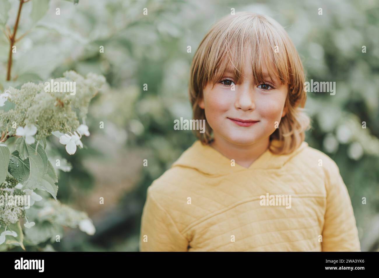 Outdoor fashion portrait of cute little boy wearing yellow hoody ...
