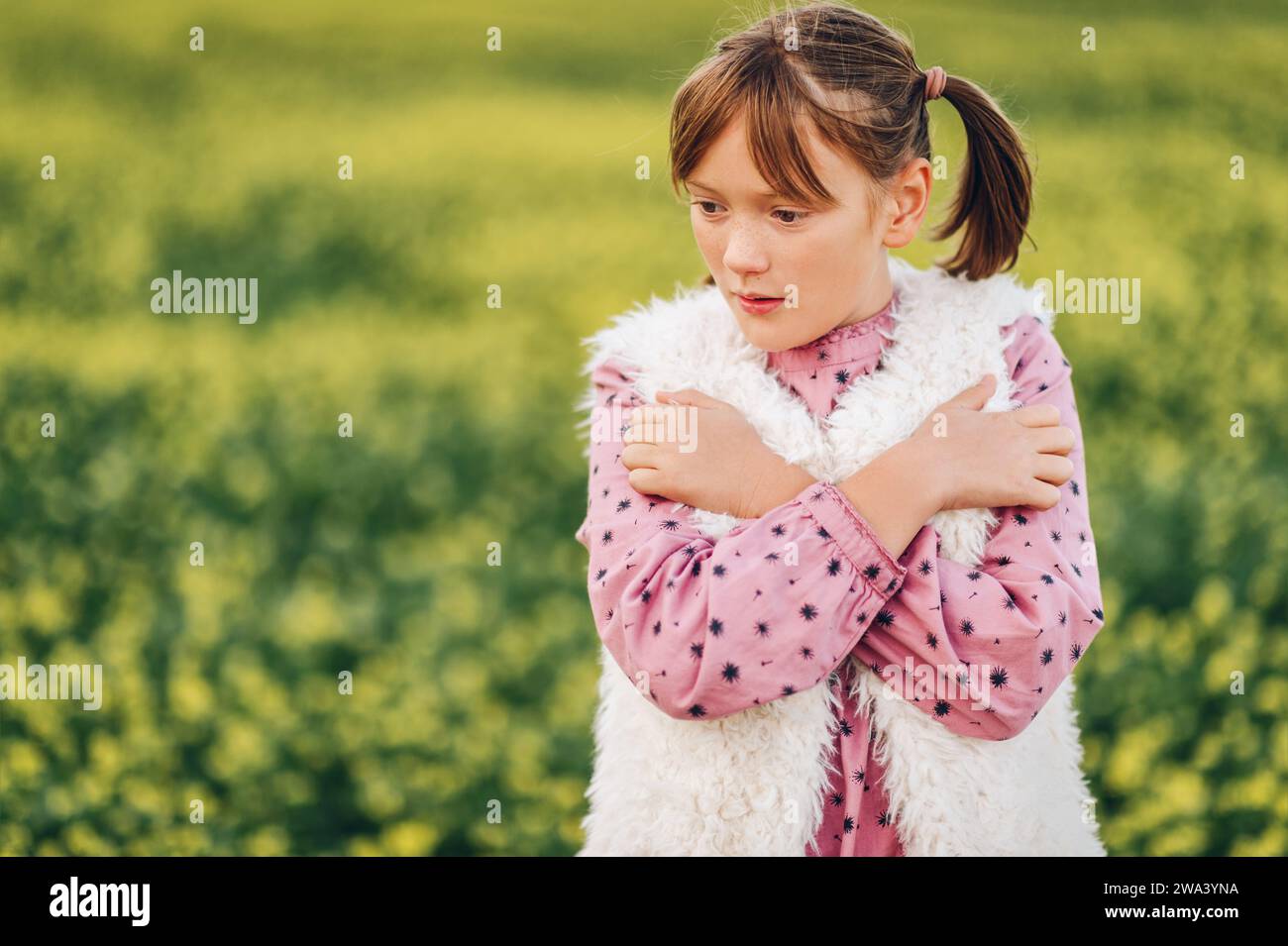 Outdoor portrait of pretty 10 year old girl, wearing pink vintage dress ...