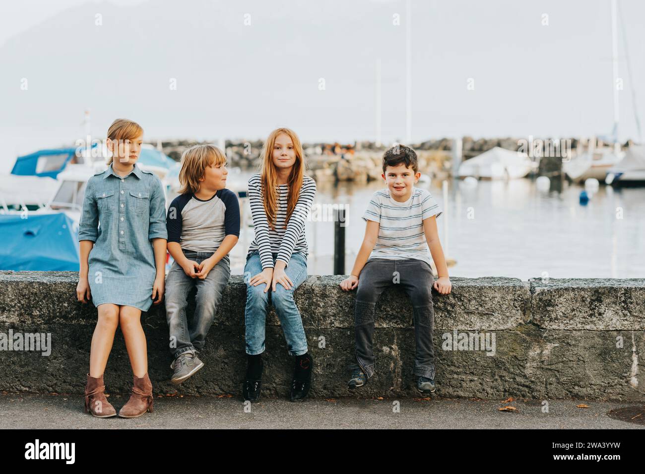 Outdoor portrait of 4 fashion kids playing together outside Stock Photo ...