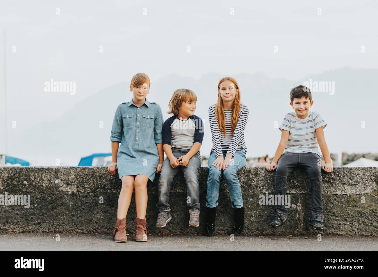 Outdoor portrait of 4 fashion kids playing together outside Stock Photo ...