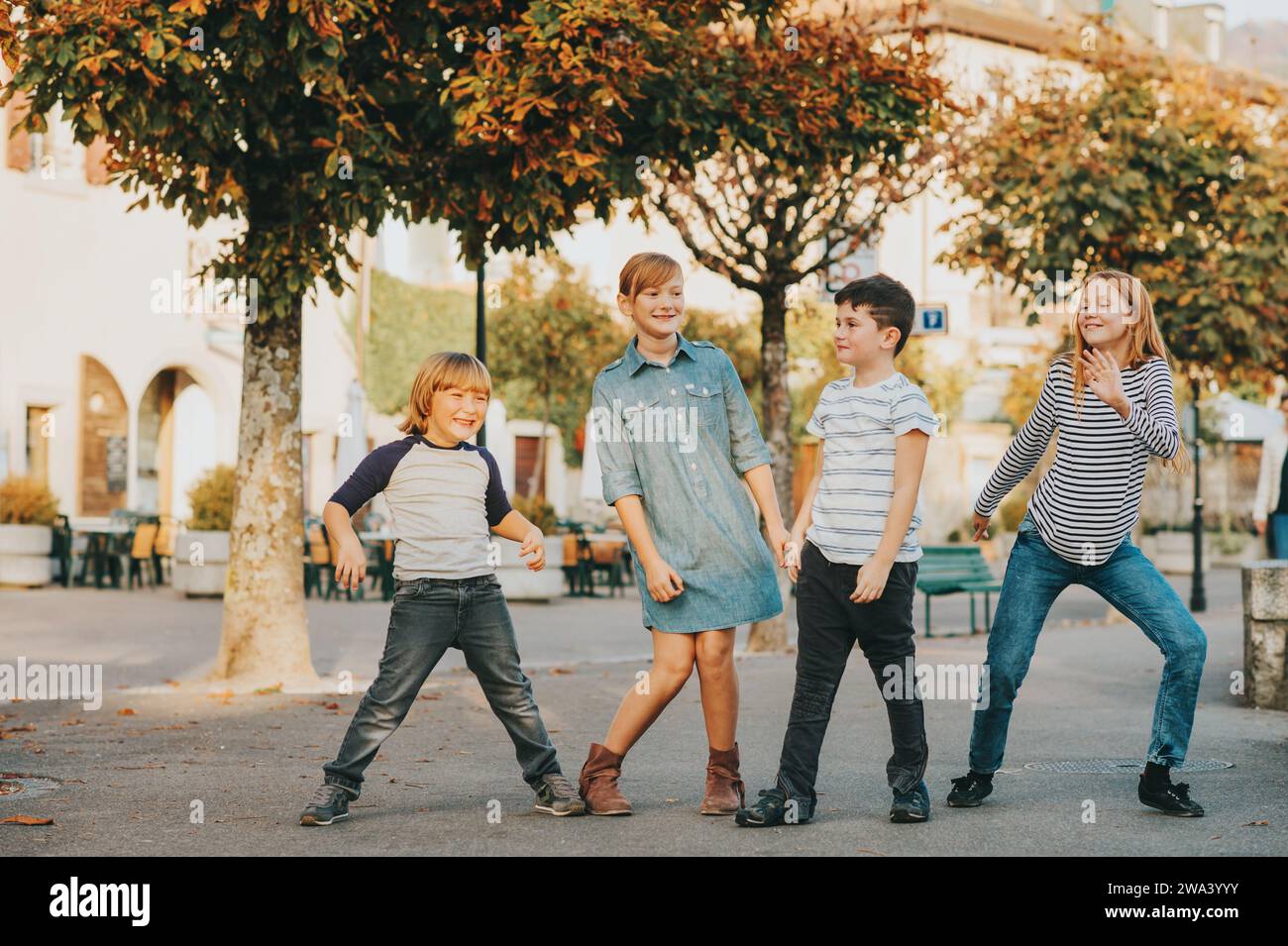 Outdoor portrait of 4 fashion kids playing together outside, children ...