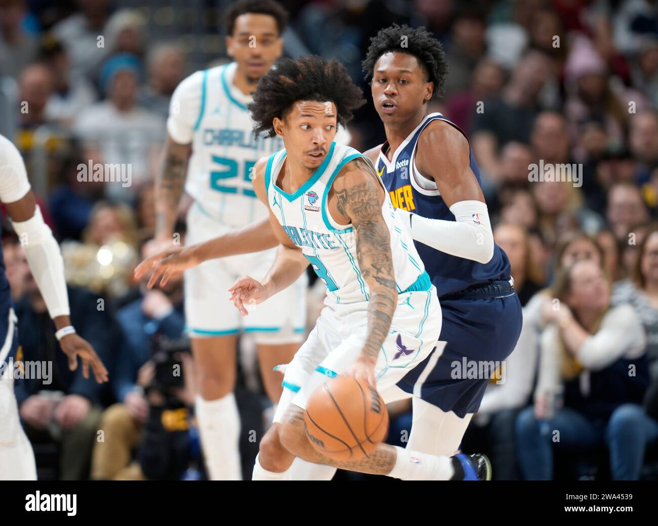 Charlotte Hornets guard Nick Smith Jr., front, picks up a loose ball as ...