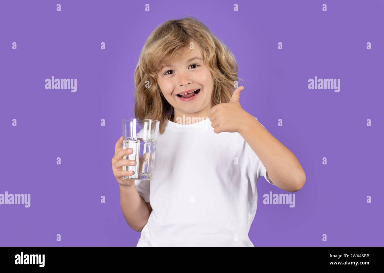 Kid drinking a fresh glass of water, isolated on studio background ...