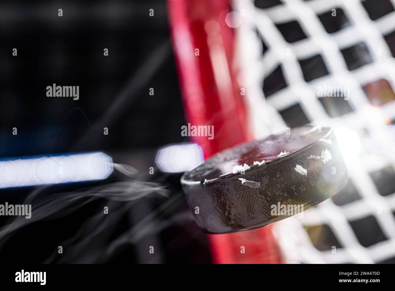An ice hockey puck flying mid-air as it as it scores a goal Stock Photo ...