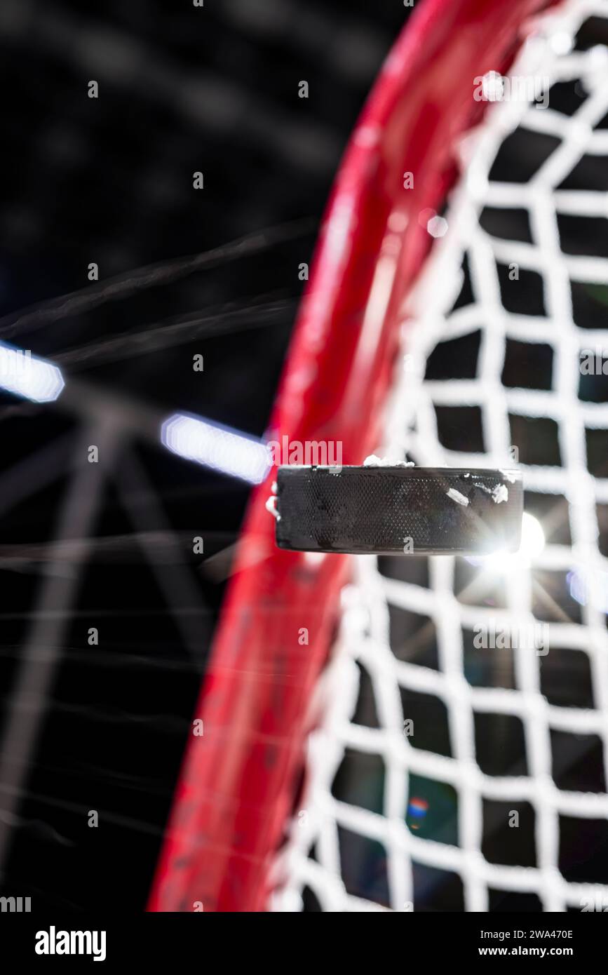 An ice hockey puck flying mid-air as it as it scores a goal Stock Photo ...