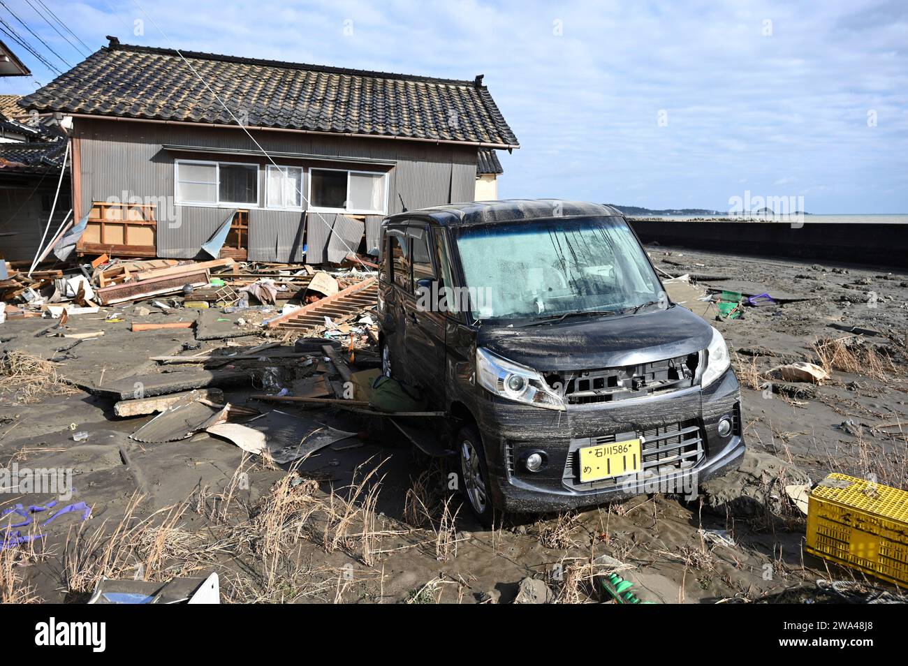 A car and houses are washed awary by a strong tsunami occurred in Suzu ...