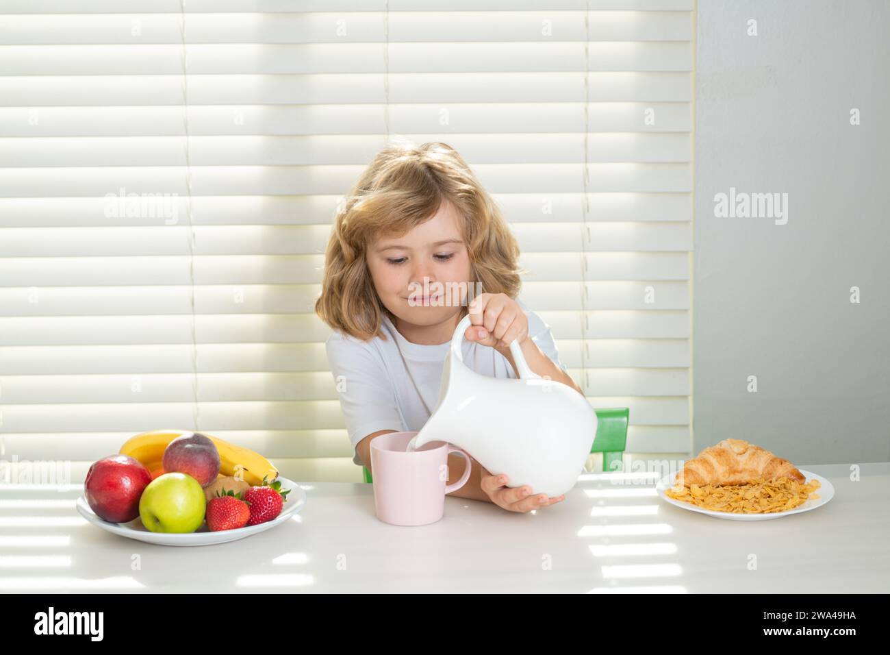 Cute child pouring whole cows milk. Healthy nutrition for children ...