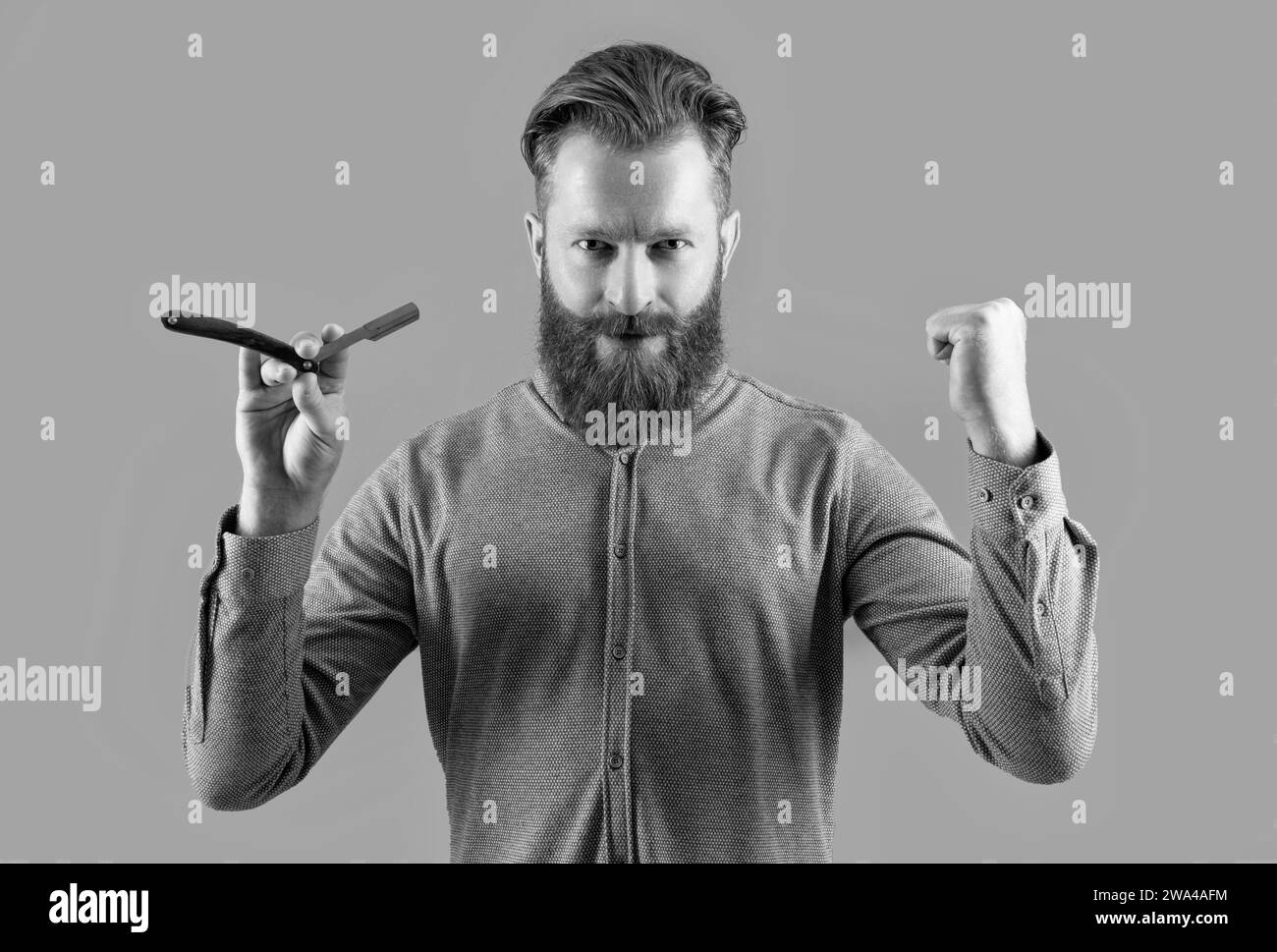 barber man shaving with blade expressing success. man in barber studio ...