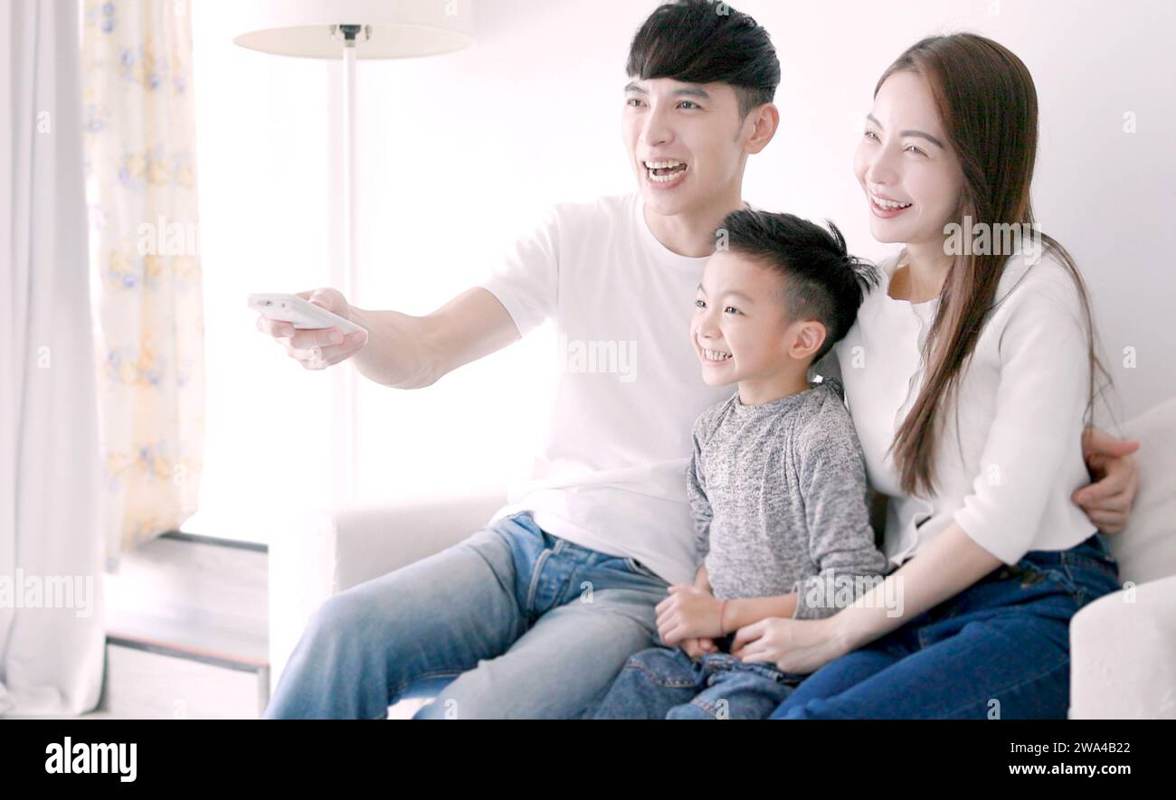 Relaxed Asian family watching TV together at home Stock Photo - Alamy