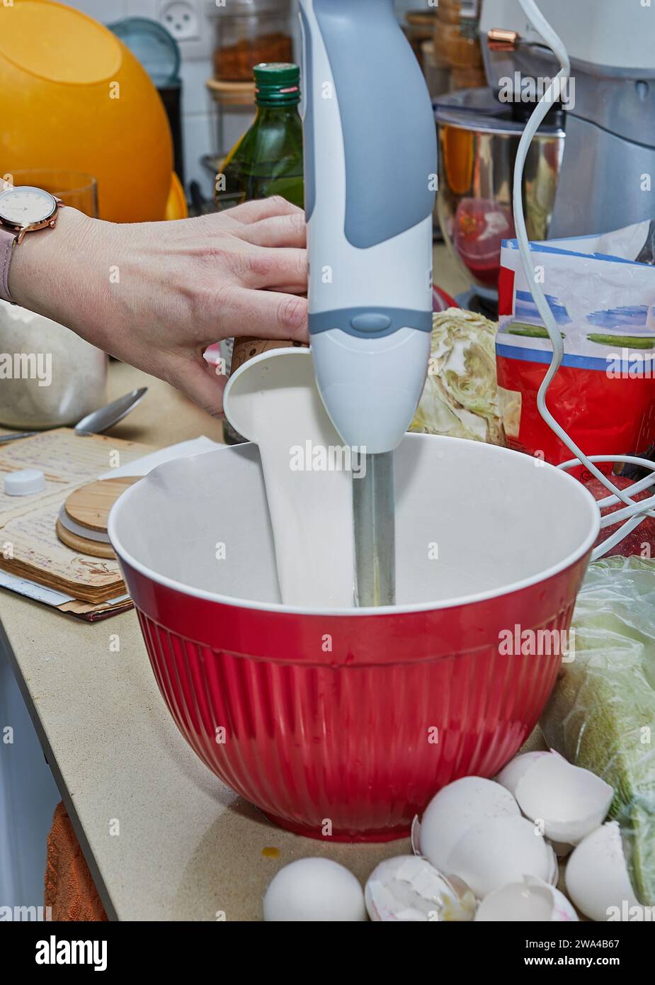 A busy homemaker is seen in her kitchen, skillfully whisking pancake ...