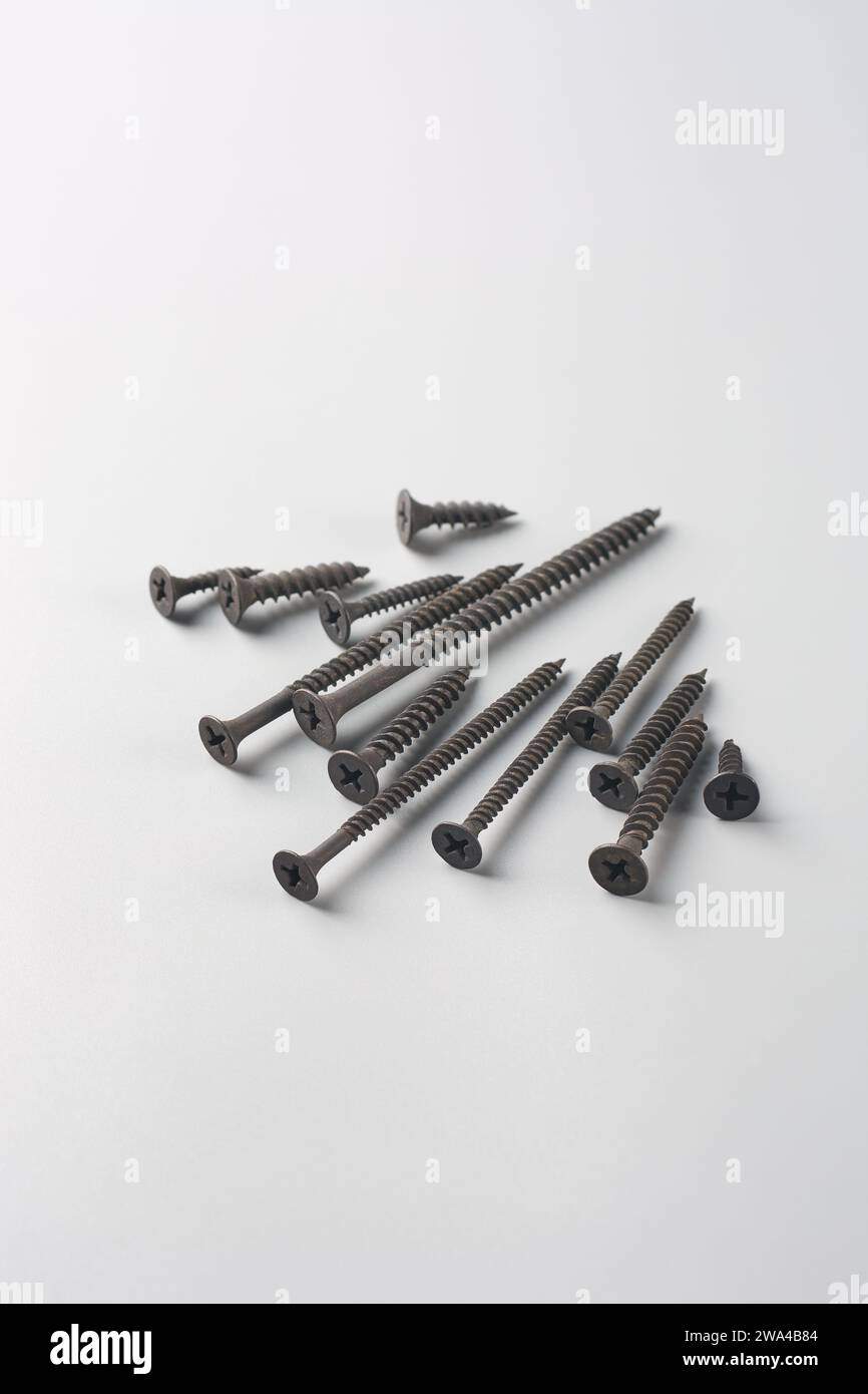 set of scattered metal screws isolated on neutral grey background ...
