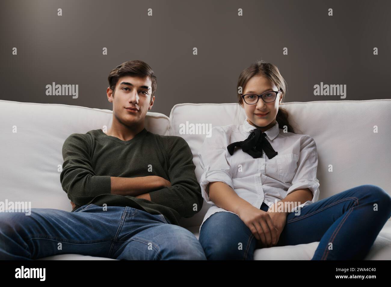 Relaxed in green, the young man lounges beside a bespectacled woman in ...