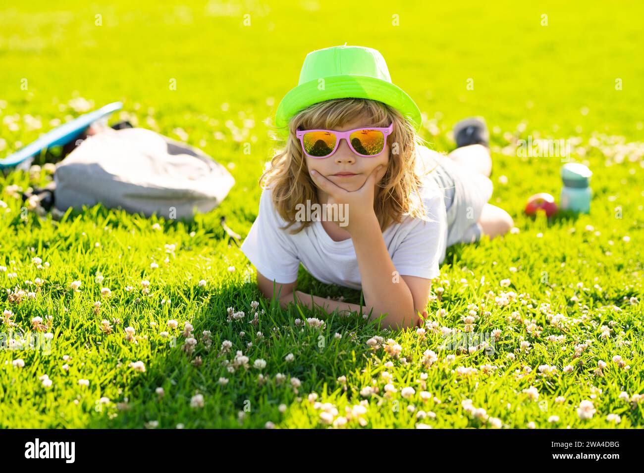 Summer holiday with children. Kids relaxation. Child laying in grass in ...